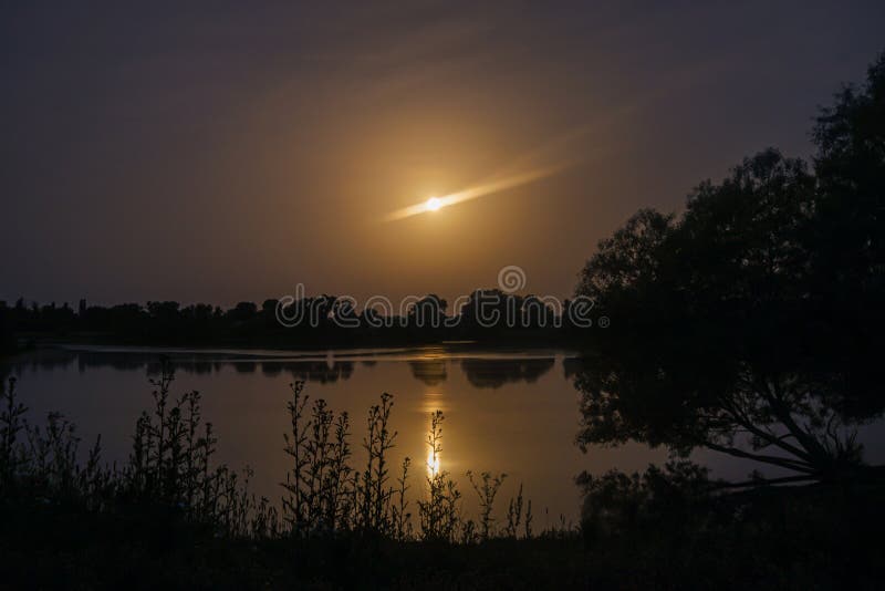 A Blood Moon and the Planet Mars Rise Over Lake Stock Photo - Image of ...