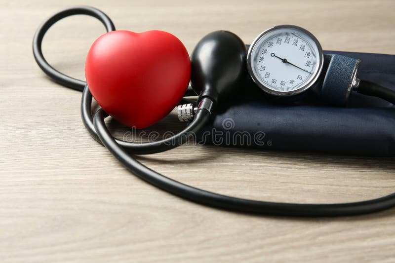 Blood Pressure Measuring Device and Squeeze Heart on Wooden Table Stock ...