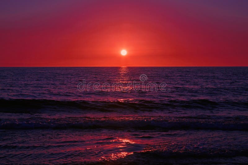 The Blood Red Sun Sets on the Blue Ocean. Dramatic Sunset on the Sea ...