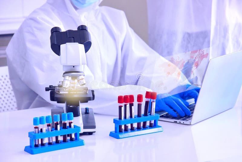 Blood Testing Glass Tubes on Table with Doctor Working with Laptop in ...