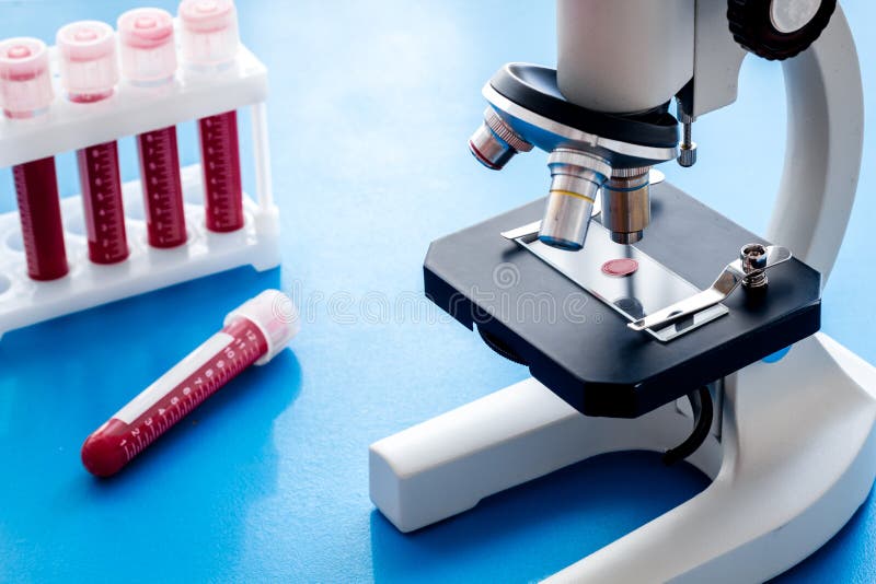 Blood Testing with Microscope in Laboratory. Sample in Hands on Blue ...