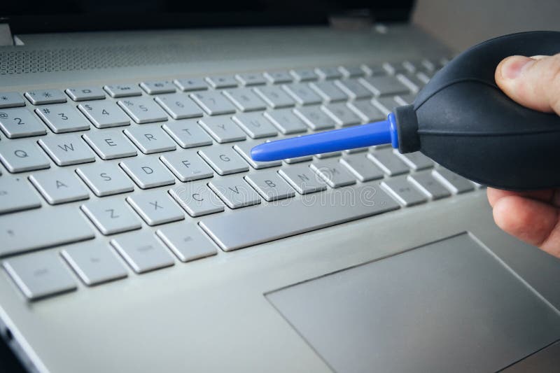 Blowing Debris from Under the Buttons on the Keyboard with a Special ...