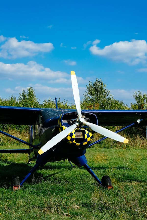 Blue Airpane Parked on the Grass at the Airfield Stock Photo - Image of ...