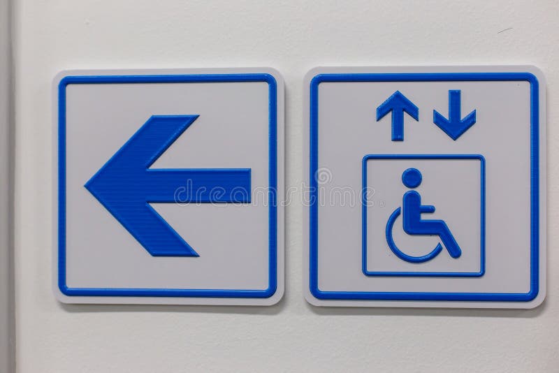 A Blue Arrow and Elevator Access Signs Disabled Person on the Wall ...
