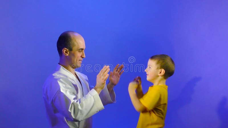 On a Blue Background, Dad and Son are Training Hand Strikes on the ...