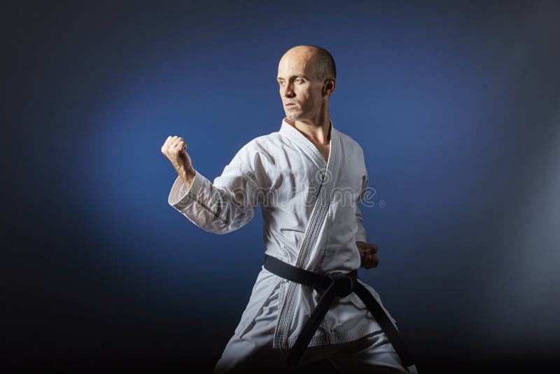 On a Blue Background with a Gradient, an Athlete with a Black Belt ...