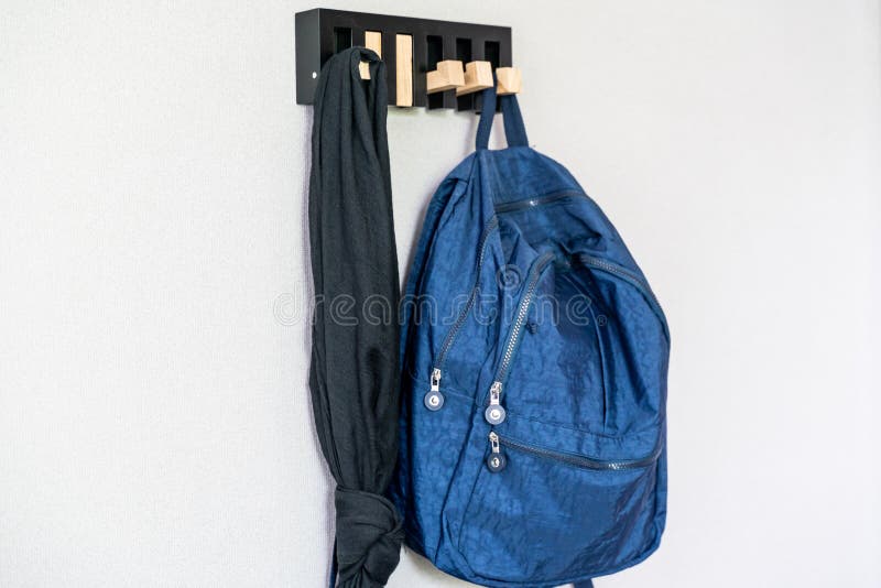 Blue Backpack is Hanging on the Wooden Hanger on White Wall Stock Photo ...