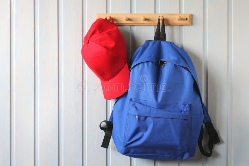 Blue Backpack and a Red Baseball Cap Hang on a Wooden Hanger Stock ...