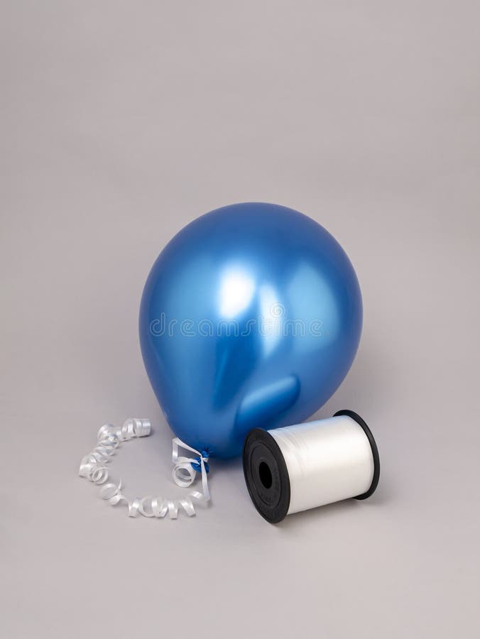Blue Balloon with White Ribbon on Grey Background and Ribbon Spool ...