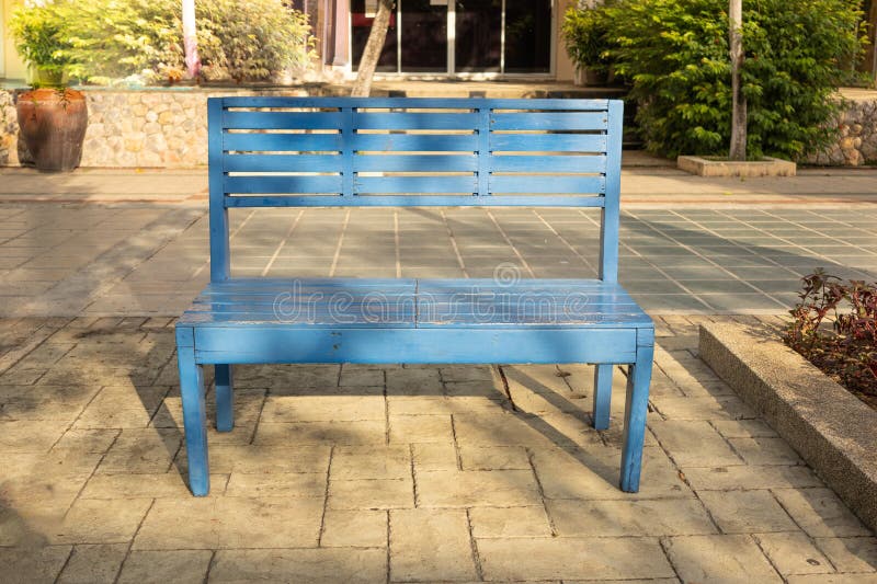 A Blue Bench Stands on the Brick Sidewalk in Front of the Building ...