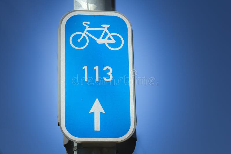 Blue Bicycle Sign on Pillar on a Blue Background Stock Photo - Image of ...