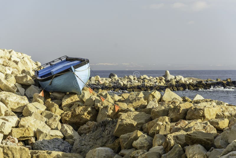 Litle boat on the rocks stock photo. Image of broken - 106958706