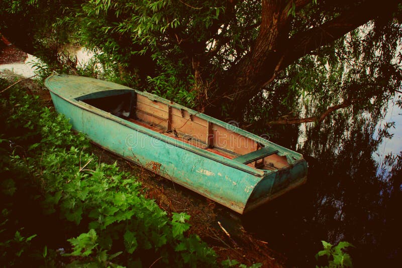 Blue Boat in the Shade of a Tree by the River Stock Photo - Image of ...