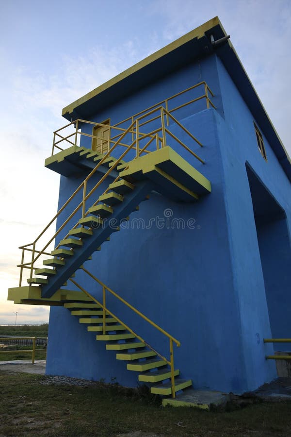 A Blue Building with a Yellow Ladder Stock Image - Image of sunlight ...