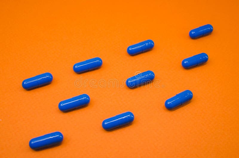 Blue Capsule Tablets on an Orange Background Stock Photo - Image of ...