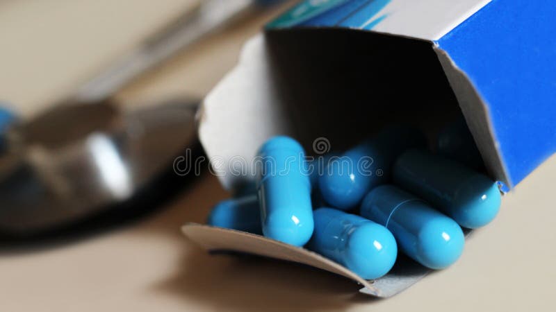 Blue Capsules and a Box of Medication Stock Photo - Image of sick ...