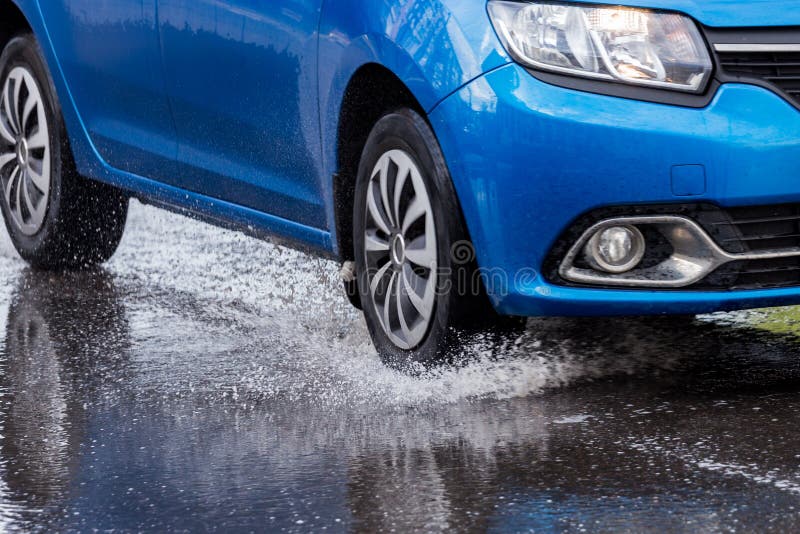 Blue Car Crossing Puddle with Water Splash at Daylight Closeup with ...