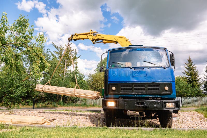 A Blue Cargo Loader with a Manipulator Unloads the Delivered Building ...