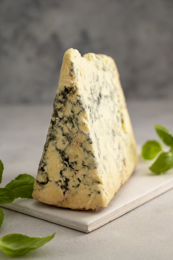 Blue Cheese Piece with Fresh Basil Leaves Over Gray Background. One ...