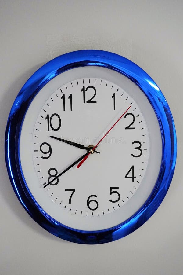 A Blue Clock Hangs on a White Wall Stock Image - Image of brand, clock ...