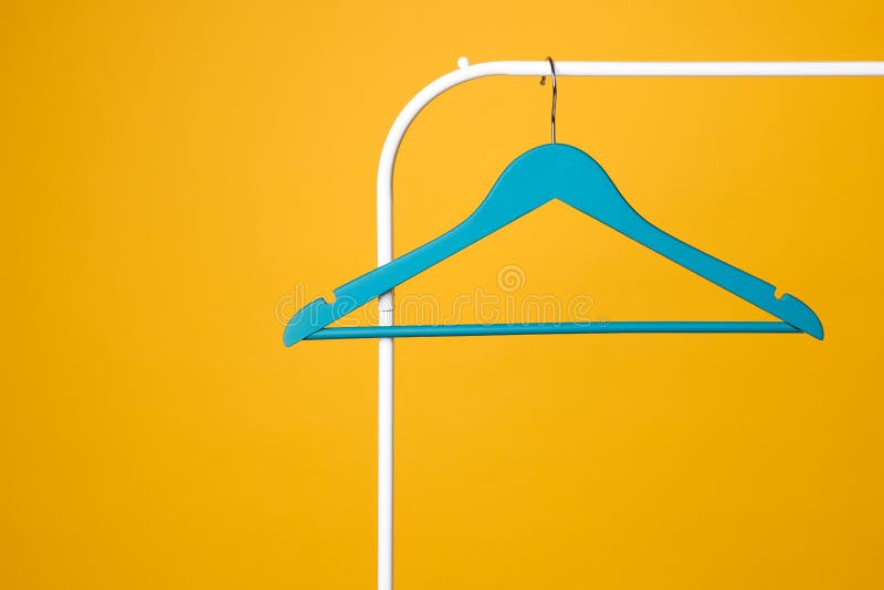 Blue Clothes Hanger on Metal Rack Against Yellow Background Stock Image ...