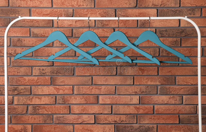 Blue Clothes Hangers on Rack Near Red Brick Wall Stock Image - Image of ...