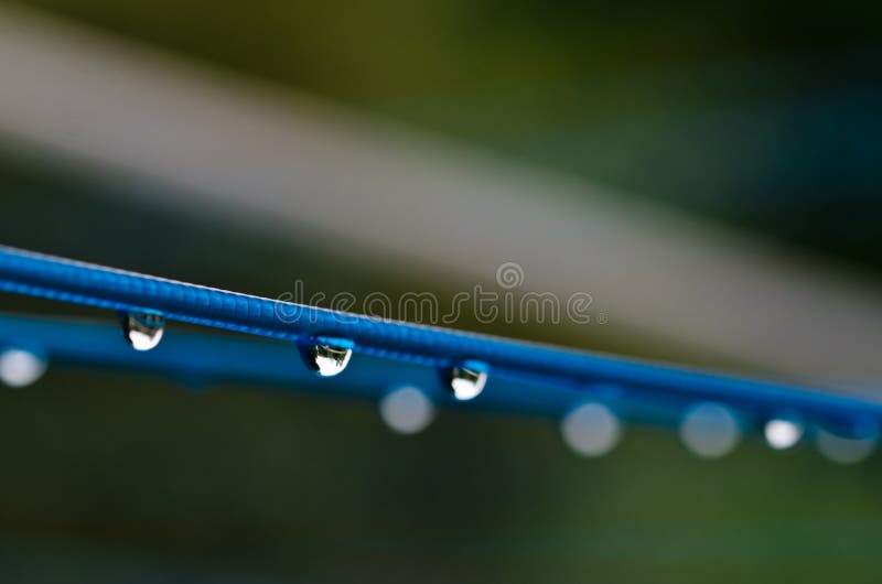 A Blue Clothing Line with Many Raindrops at the String in Front of a ...