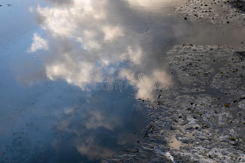 Blue Cloudy Sky Reflected in the Water with Pollution Stock Image ...