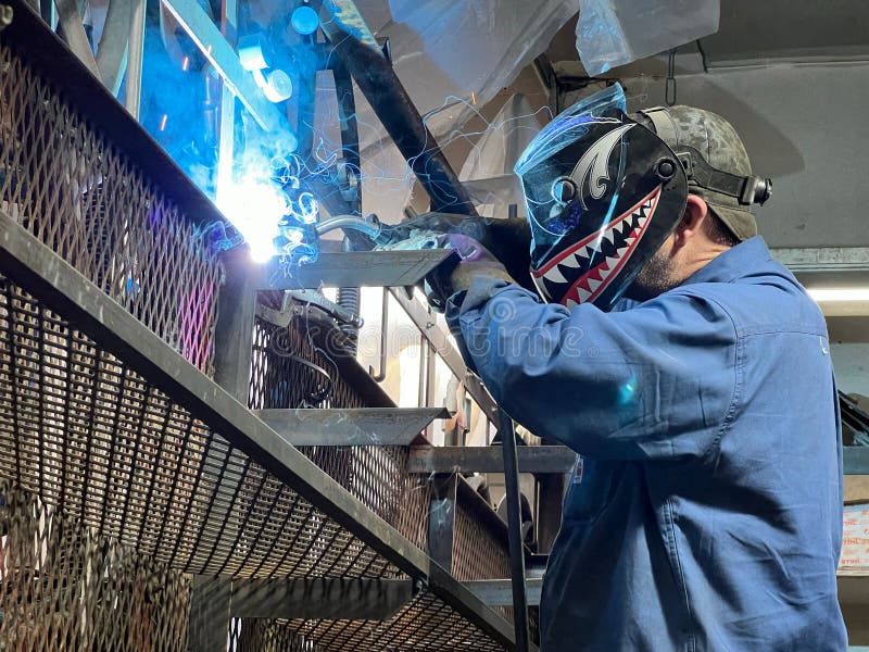 Blue Collar Worker in a Mask Welding during Building Construction Stock ...