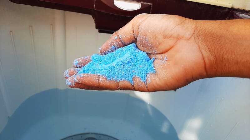 Blue Detergent Powder in Hands and Adding it in Water in Washing ...