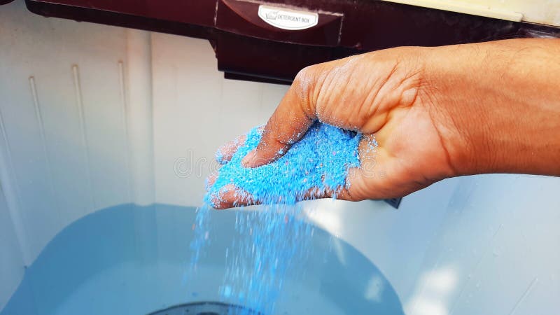 Blue Detergent Powder in Hands and Adding it in Water in Washing ...