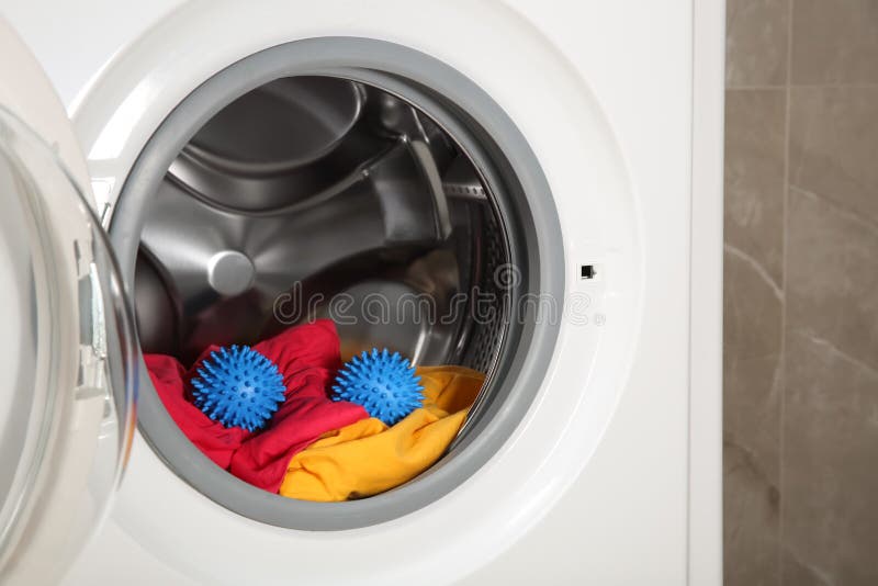 Blue Dryer Balls and Clothes in Washing Machine Drum Stock Photo ...