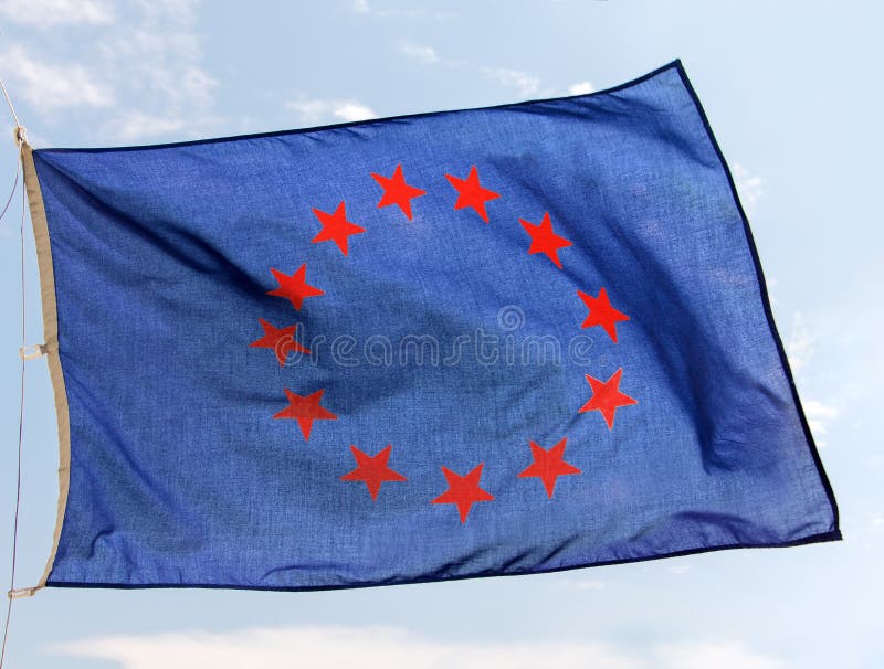 A Blue Flag with Red Stars in Circles Flutters on the Sky Stock Image ...