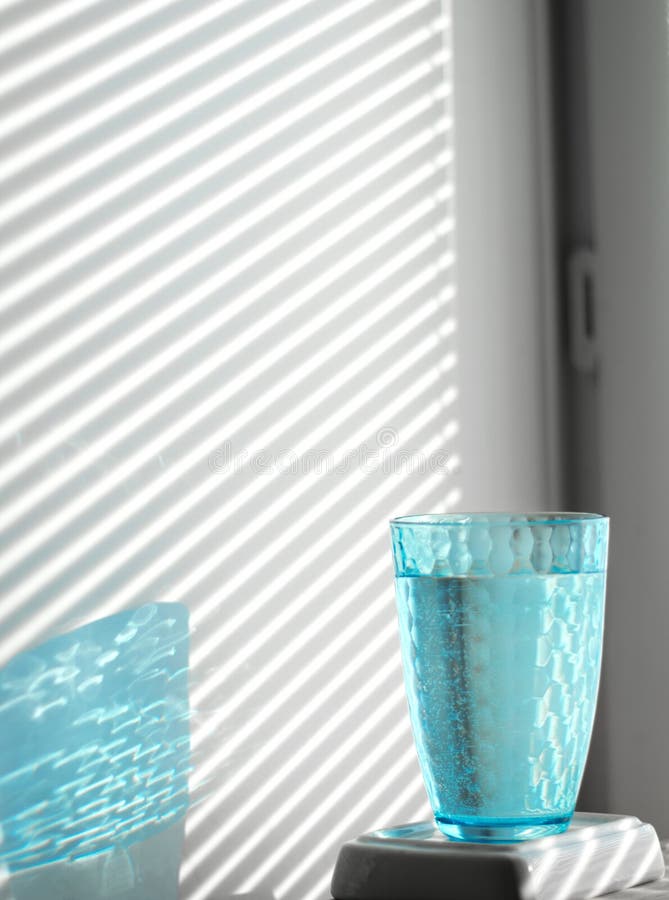 Blue Glass of Water Against the Wall with Shadows Stock Photo - Image ...