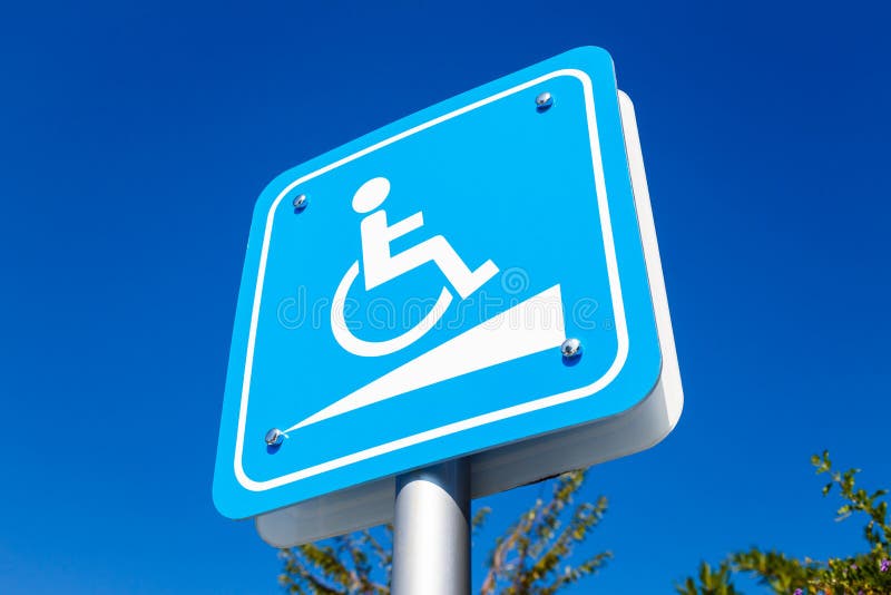 Blue Handicapped Parking Sign On A Red Brick Wall Of An Office Building ...