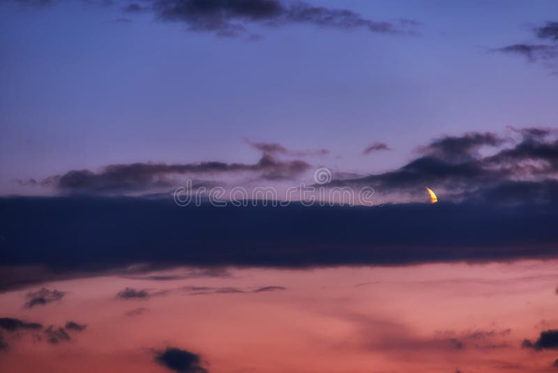 Blue Hour with the Moon and Clouds in the Red Blue Sky. Moon Obscured ...