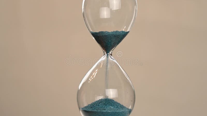 Hourglass with Blue Granules Spinning on a Black Background. Stock ...