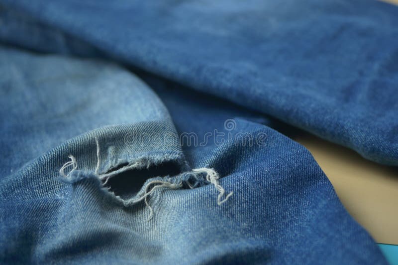 Blue Jean Texture with a Hole and Ripped Threads Showing Stock Photo ...