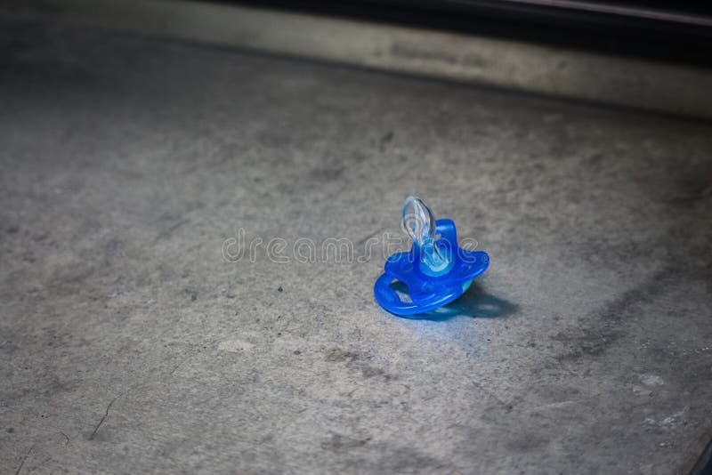 Blue Kids Pacifier Dummy Left on Concrete Surface Stock Photo - Image ...
