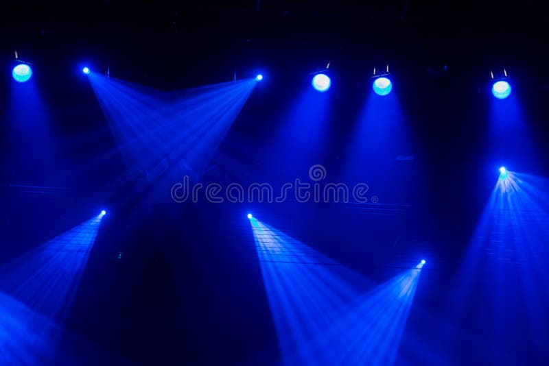 Blue Light Rays from the Spotlight through the Smoke at the Theater or ...