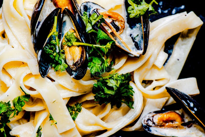 Blue Mussels and Pasta in Black Plate Stock Photo - Image of rustic ...