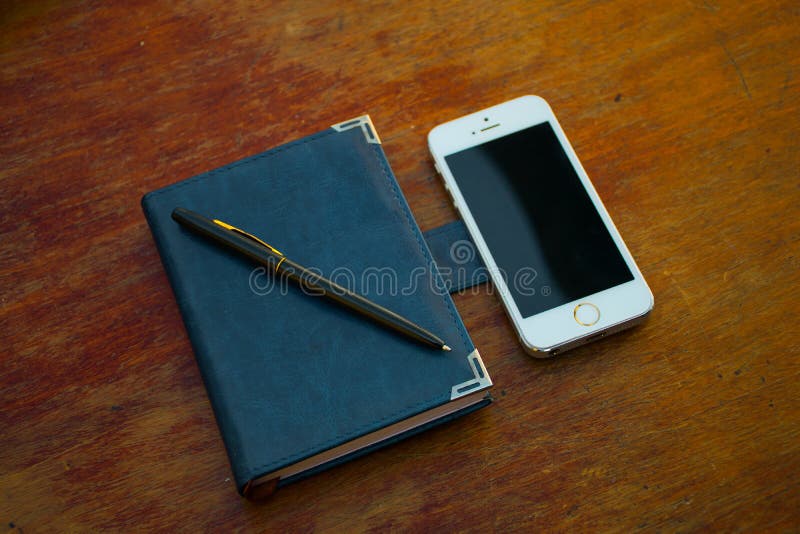 Blue Notebook with Hand and Mobile Phone on a Wooden Table Stock Image ...