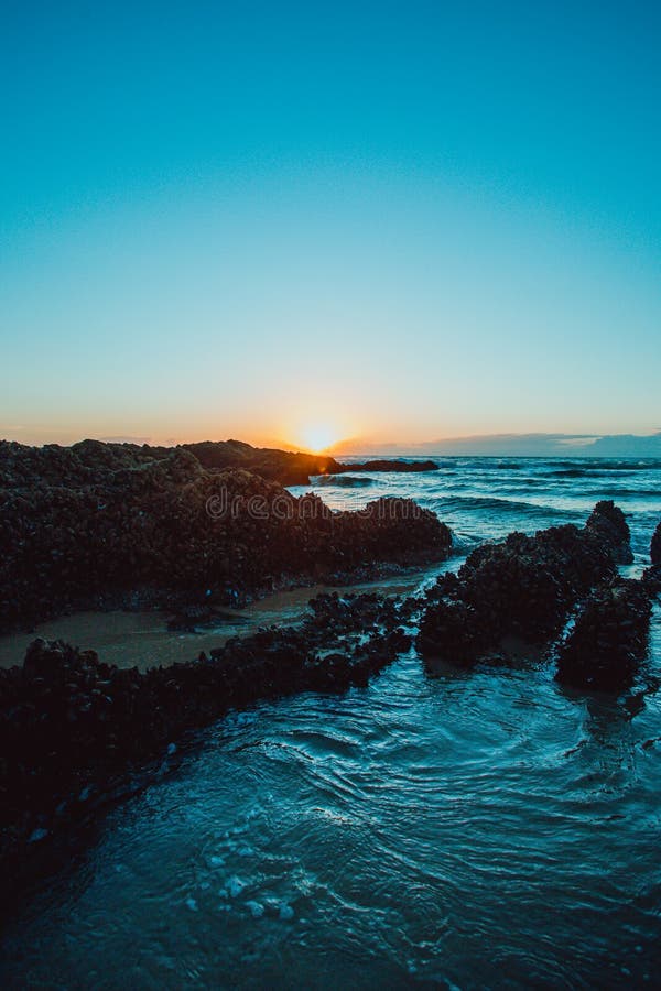 Blue and Orange Colorful Sunset Over the Rocks of the Beach Stock Photo ...