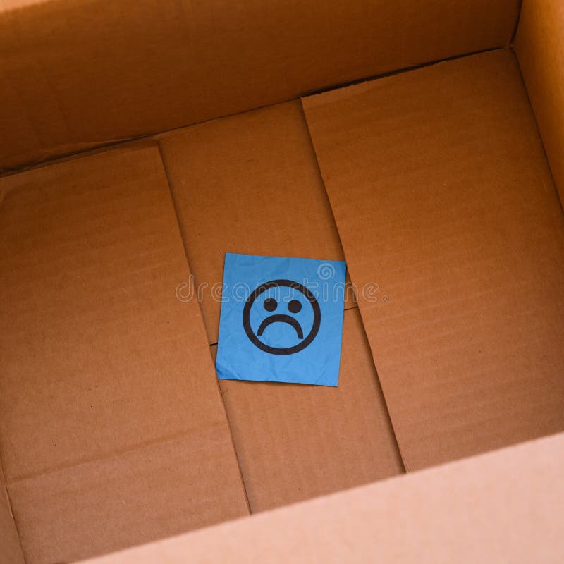 A Blue Paper Note with a Sad Face on it in a Cardboard Box Stock Image ...