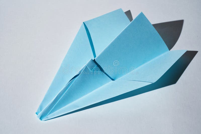 Blue Paper Plane Lying on White Background with Hard Shadows. Stock ...
