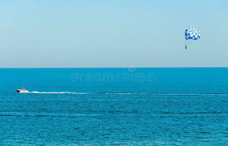 Blue Parasail Wing Pulled by a Boat in the Sea Water, Parasailing Also ...