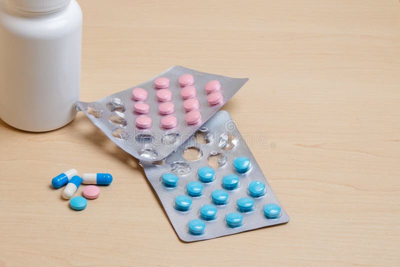 Blue and Pink Pills in the Package on the Table. Close-up Stock Photo ...