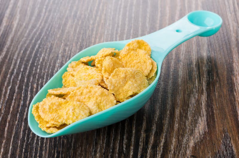 Blue Plastic Spoon with Corn Flakes on Wooden Table Stock Photo - Image ...