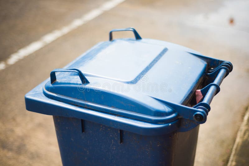 Blue Plastic Trash Can by the Roadside Stock Photo - Image of garbage ...