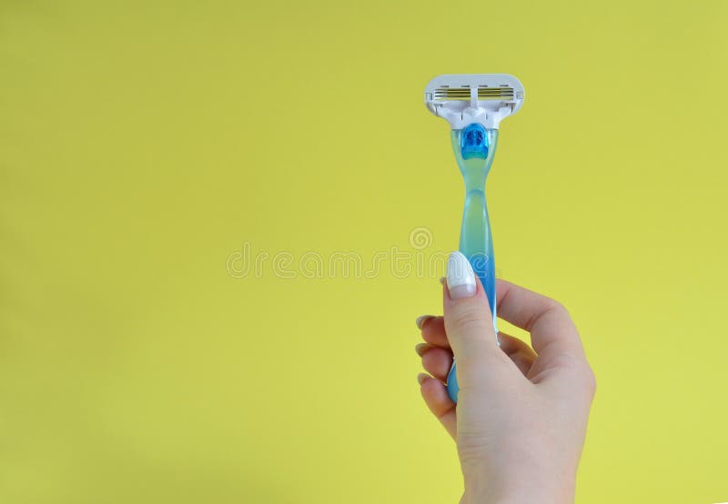 Blue Razor in Hands on a Yellow Background. Stock Image - Image of ...